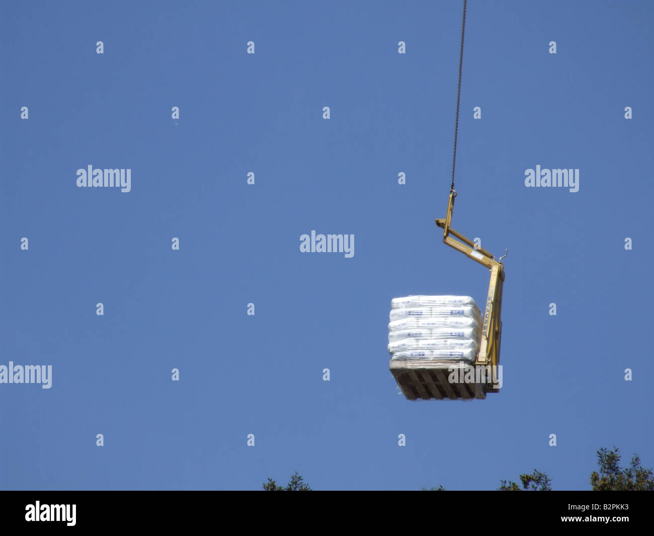 lifting crane with hanging load on building site Stock Photo - Alamy