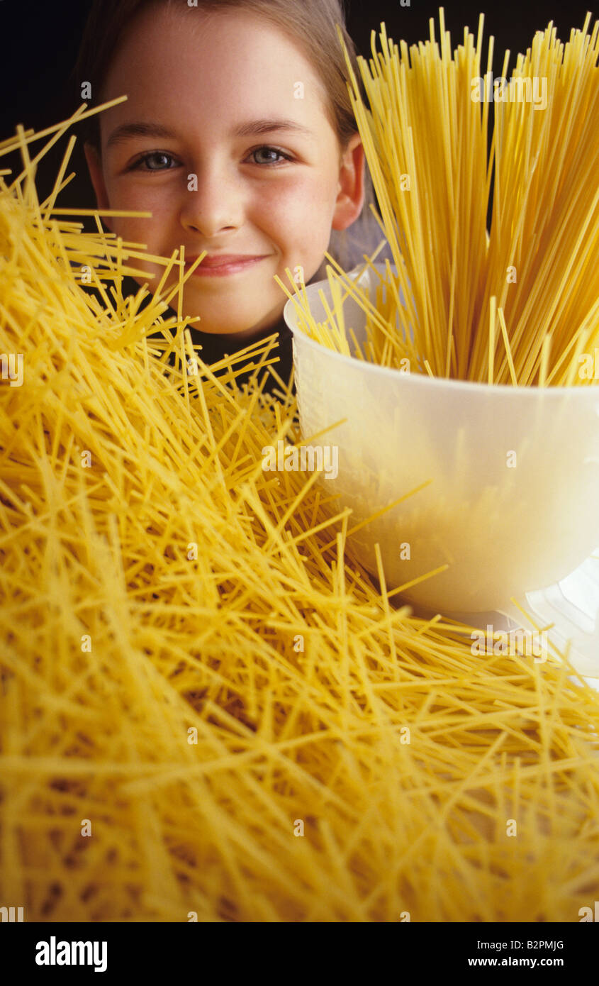 Young girl making a mess with spaghetti in kitchen fun Stock Photo - Alamy