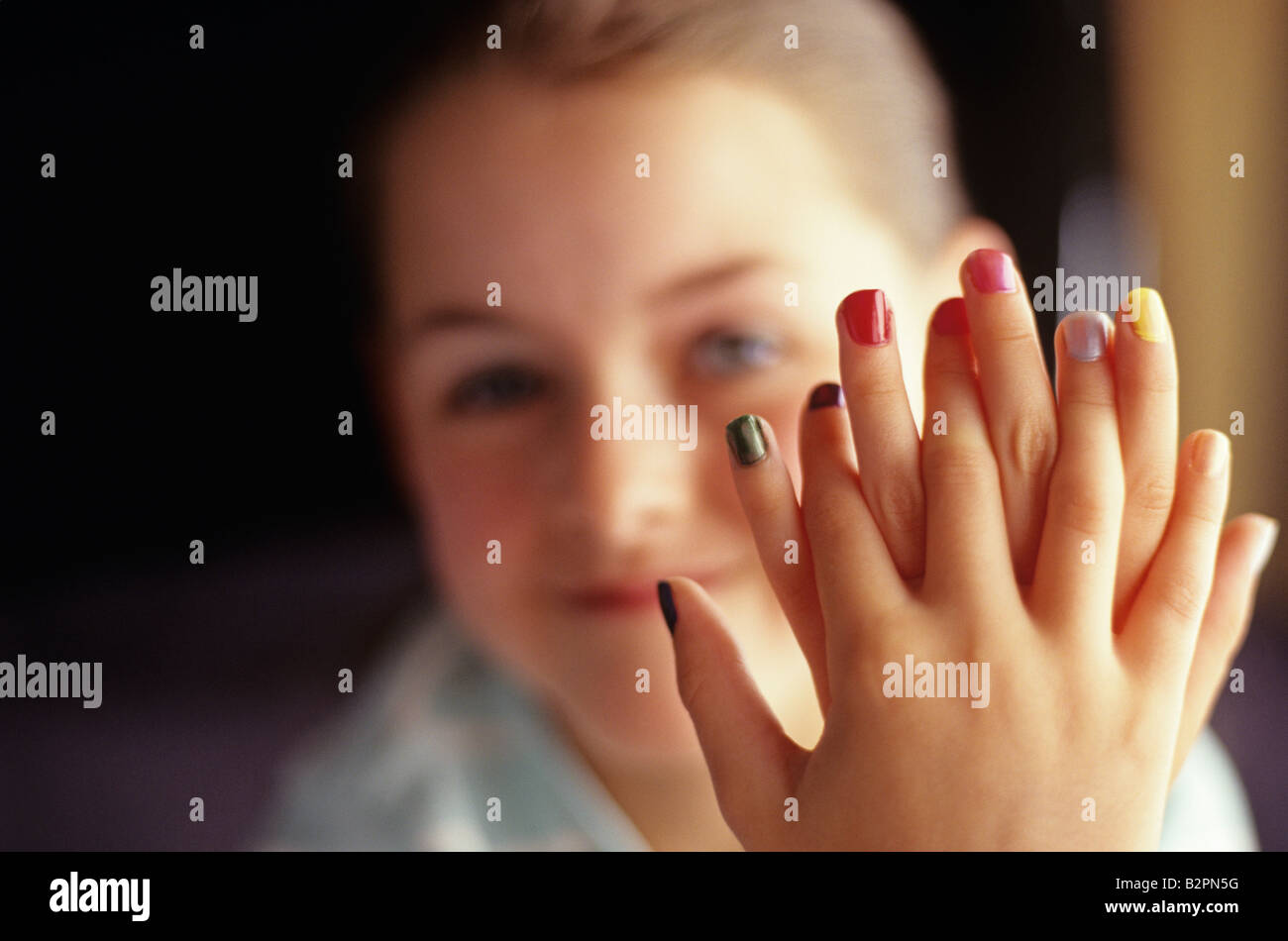 Young girl showing off her newly painted multicolored finger nails ...
