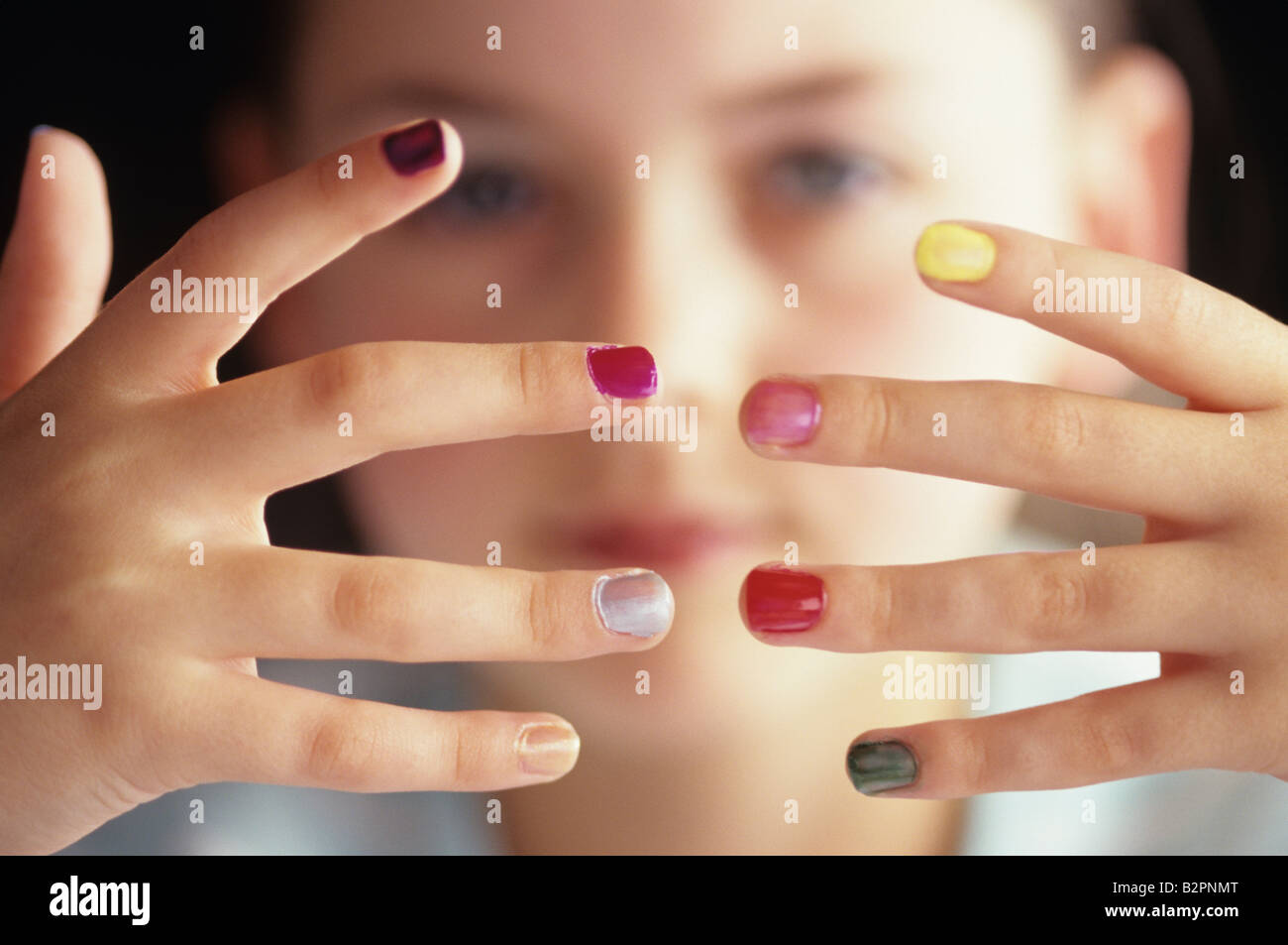 Young girl showing off her newly painted multicolored finger nails ...