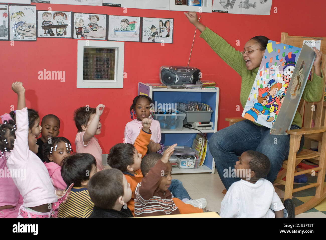 Preschool teacher reading a book to her students Stock Photo - Alamy