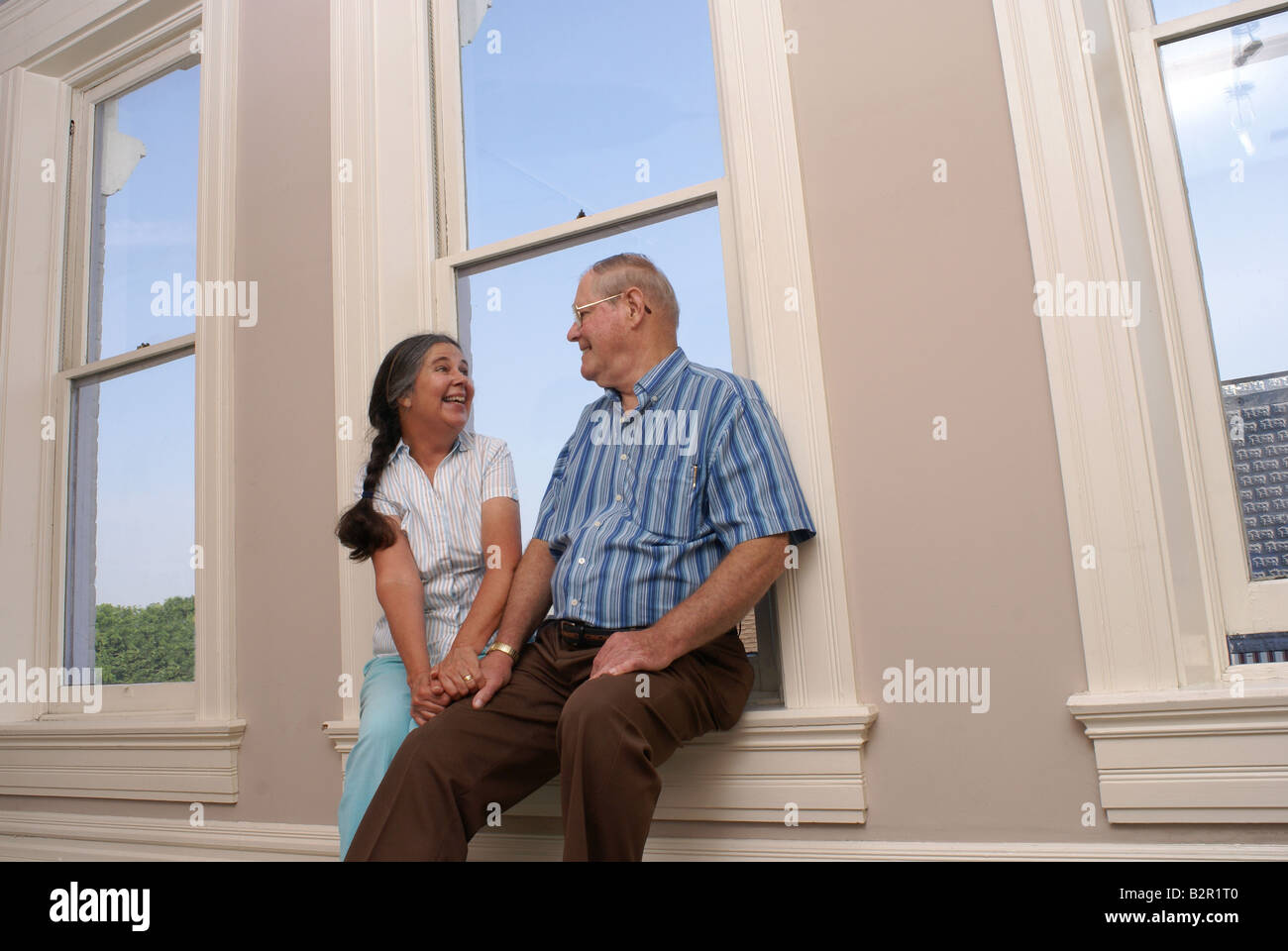 Happing Couple Sitting on Windowsill Stock Photo - Alamy