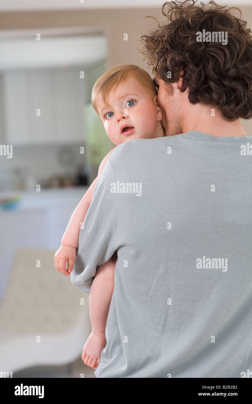 Father cuddles baby at home Stock Photo - Alamy