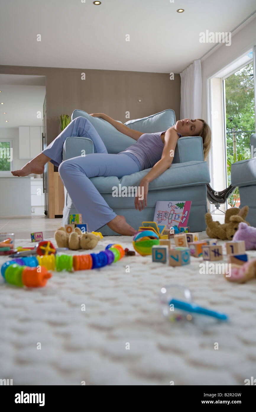 Young mother sleeping on chair Stock Photo - Alamy