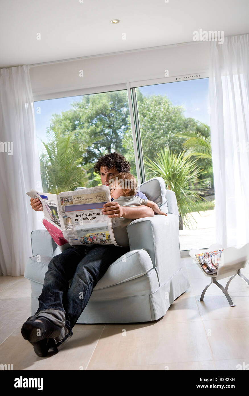 Father reading newspaper with baby Stock Photo - Alamy
