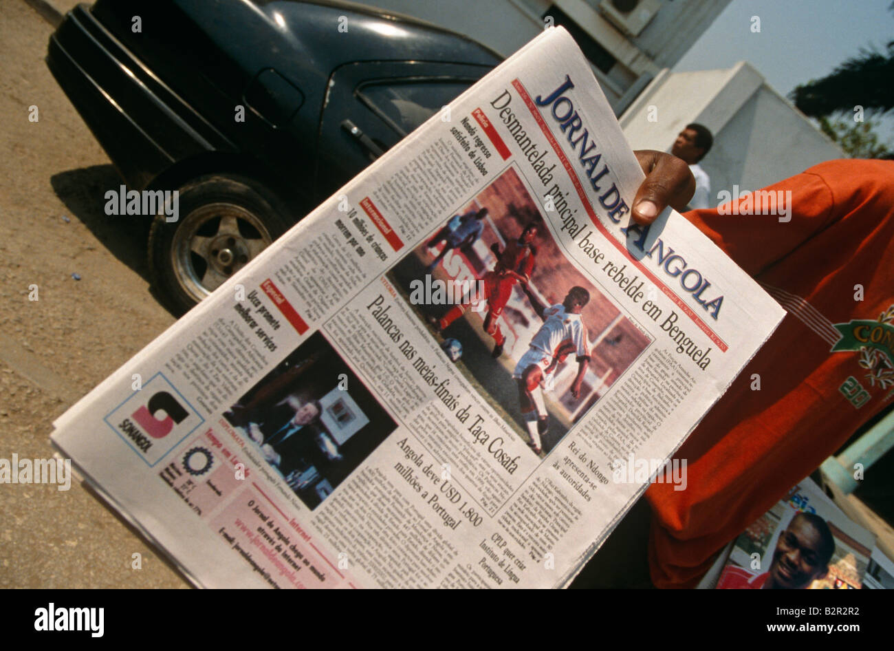Vendor holding up newspaper, Luanda, Angola Stock Photo - Alamy