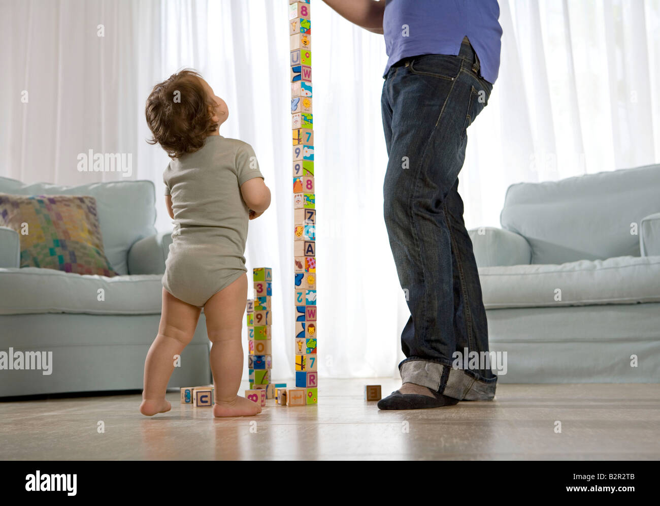 Baby watching father Stock Photo - Alamy