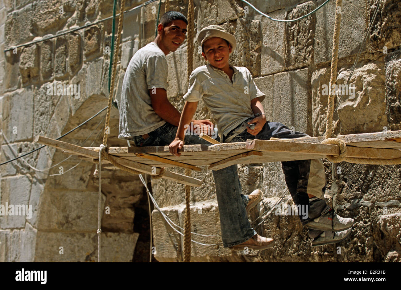 Construction workers on rope scaffold in the Old City of Jerusalem ...
