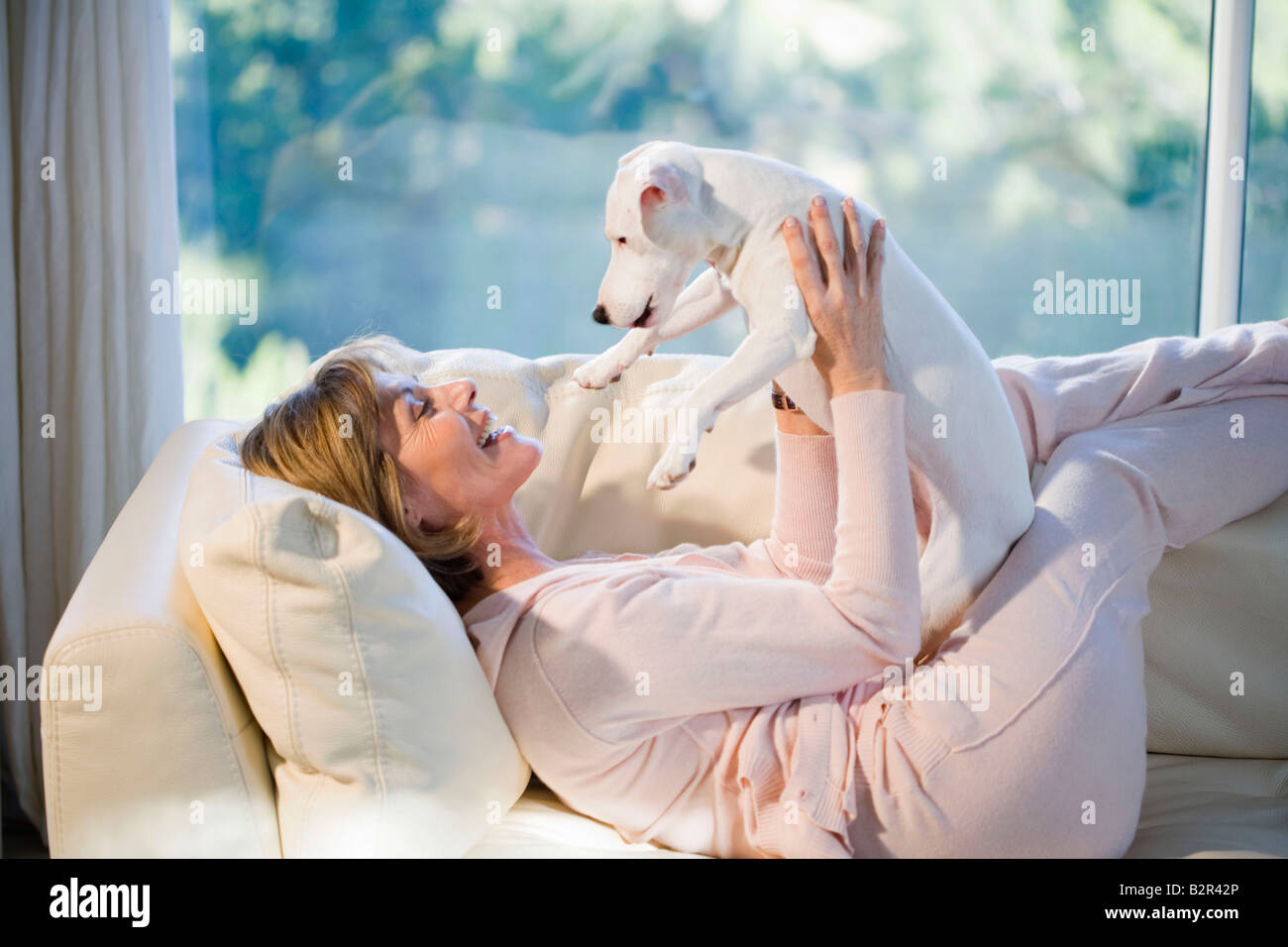 Woman Relaxing, Playing With Dog Stock Photo - Alamy