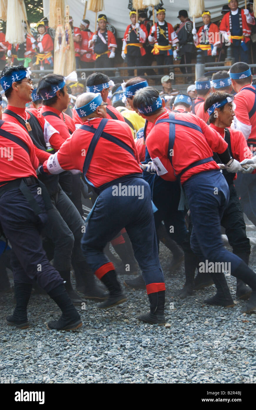 Red-clad participants pull a rope attached to the "boat" of Shimosuwa's ...