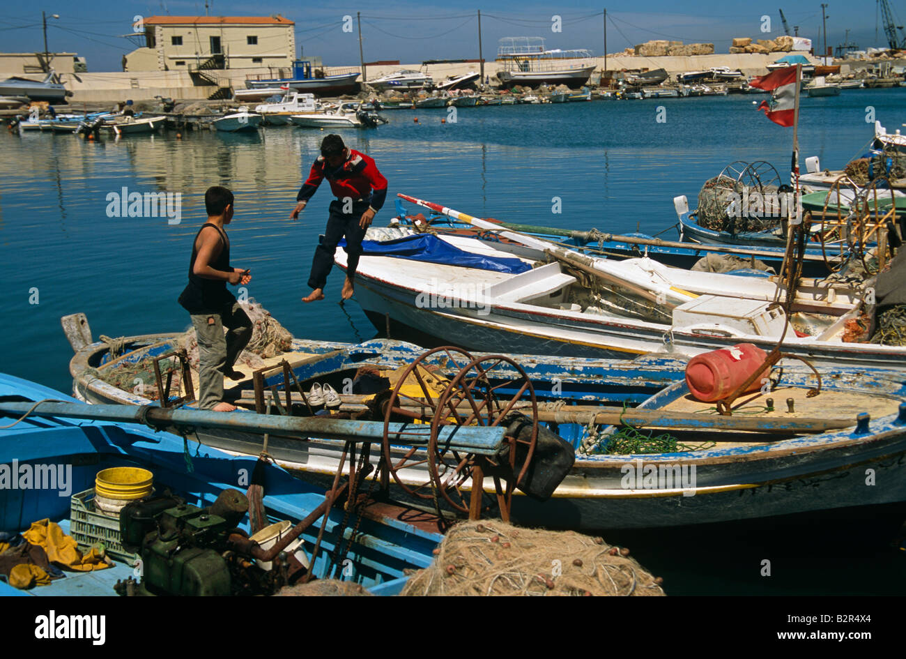 Boys playing on boats in fishing port, Saida, Lebanon Stock Photo - Alamy