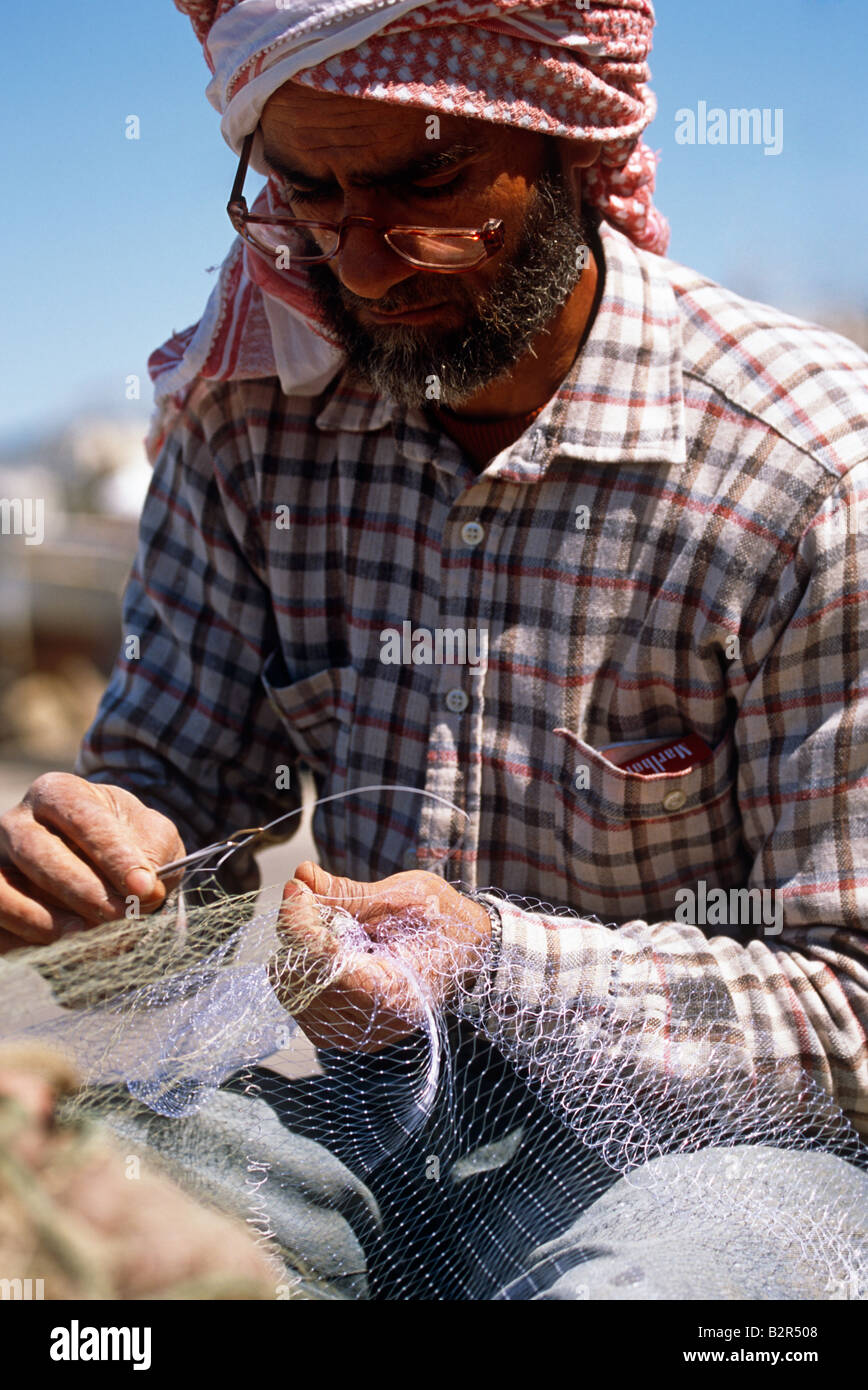 Fisherman repairing fishing net, Saida, Lebanon Stock Photo - Alamy
