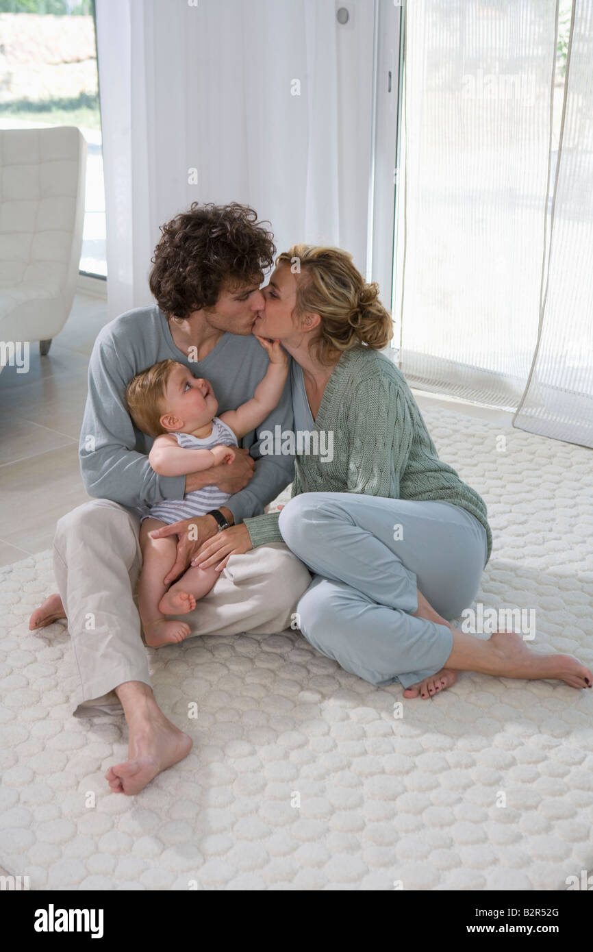 Parents kiss while baby watches Stock Photo - Alamy