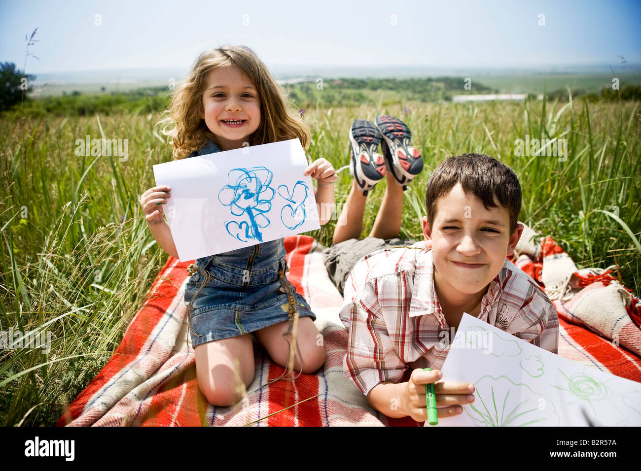Two children showing their drawings Stock Photo - Alamy