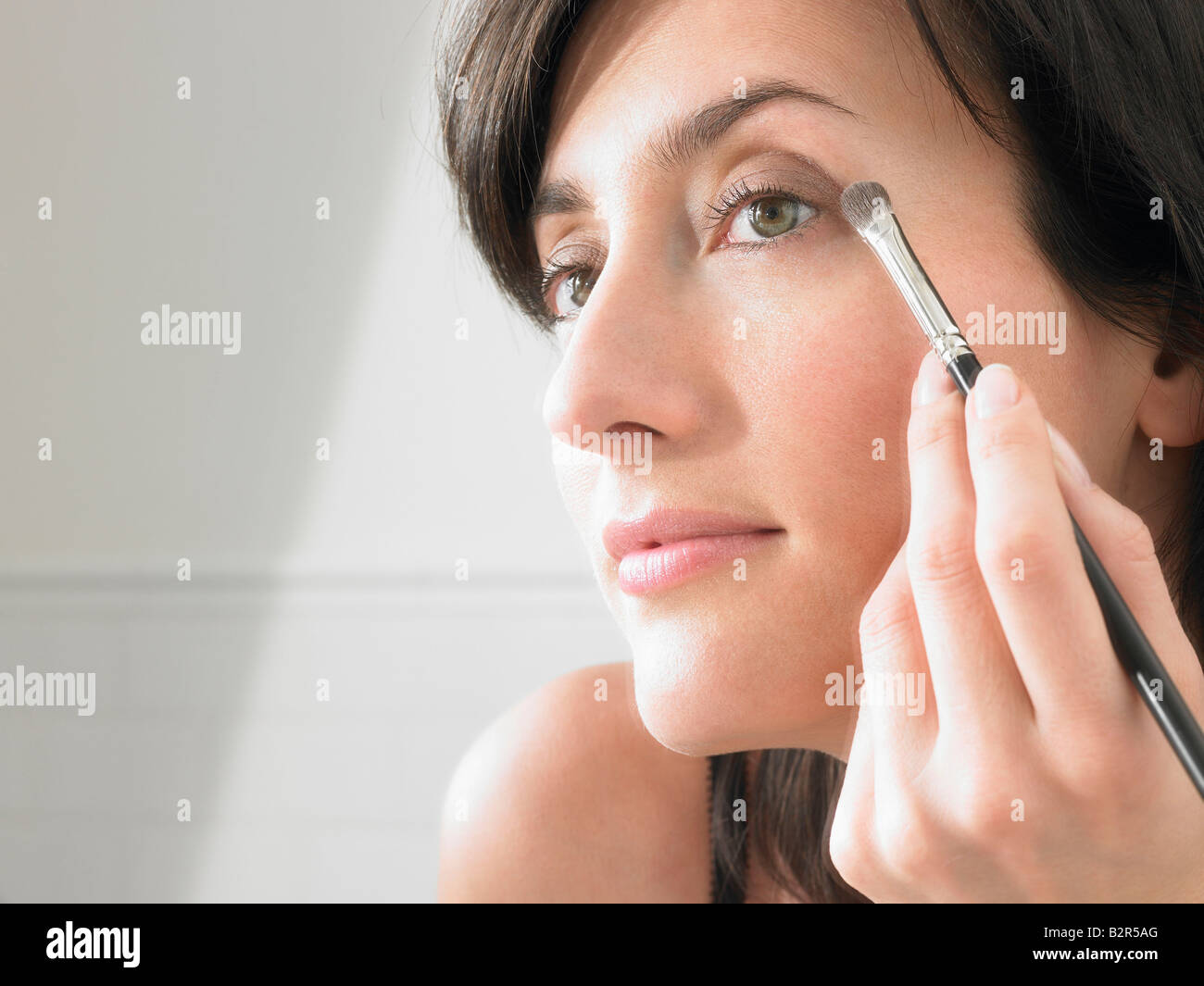Woman putting on make up Stock Photo - Alamy