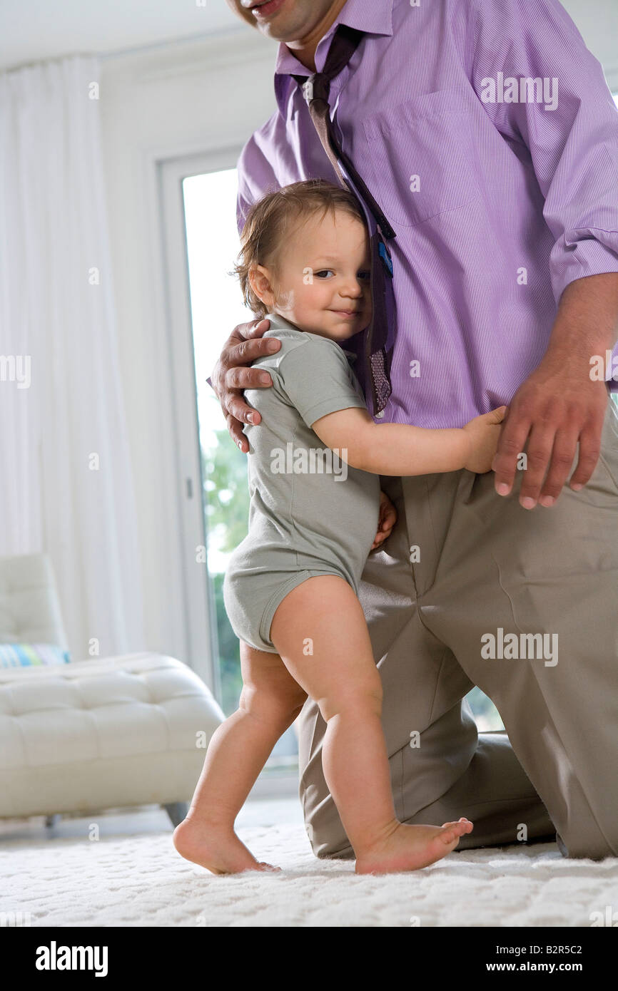 Children hugging fathers leg hi-res stock photography and images - Alamy