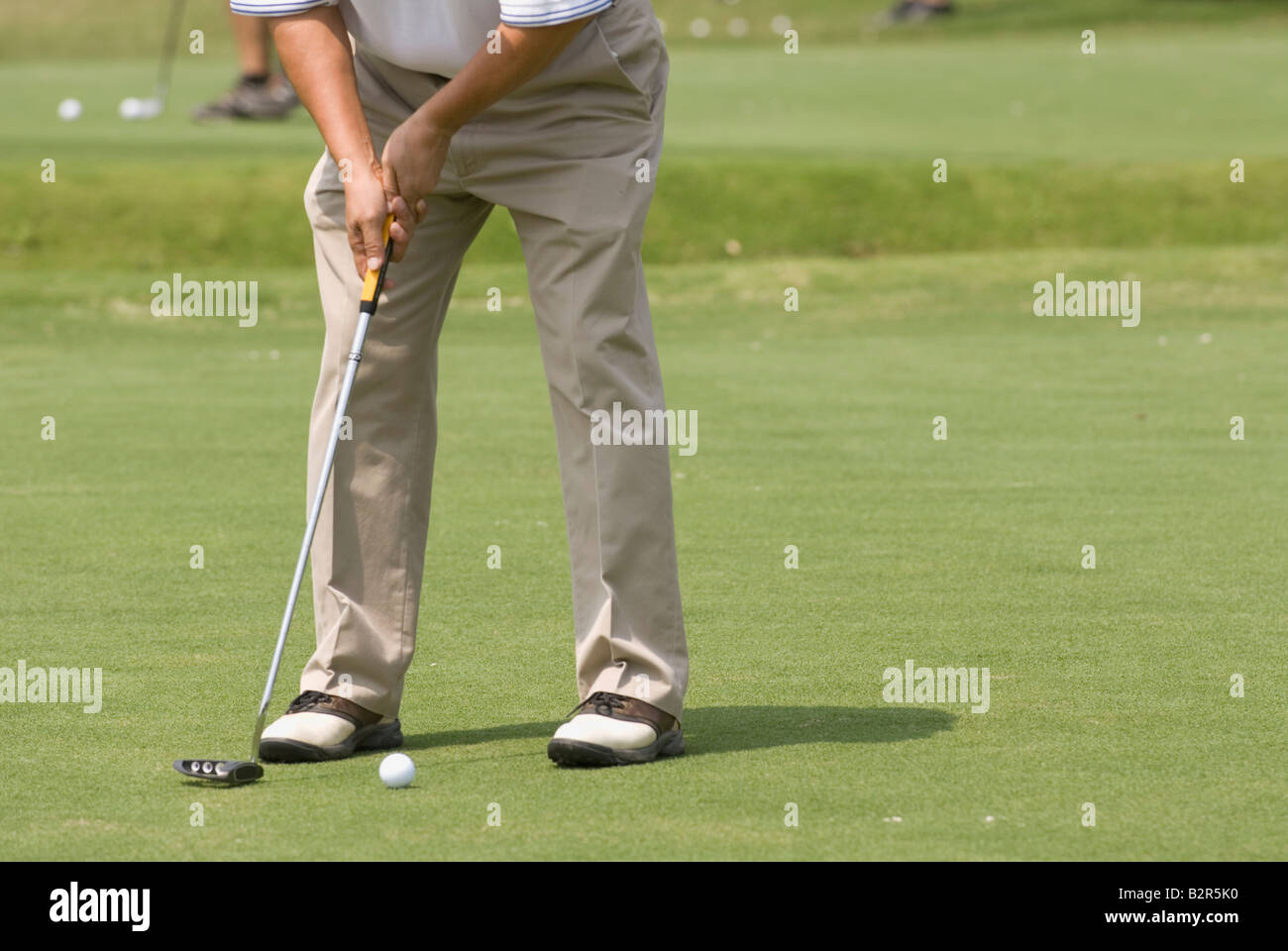Man putting on golf green, Close-up view Stock Photo - Alamy
