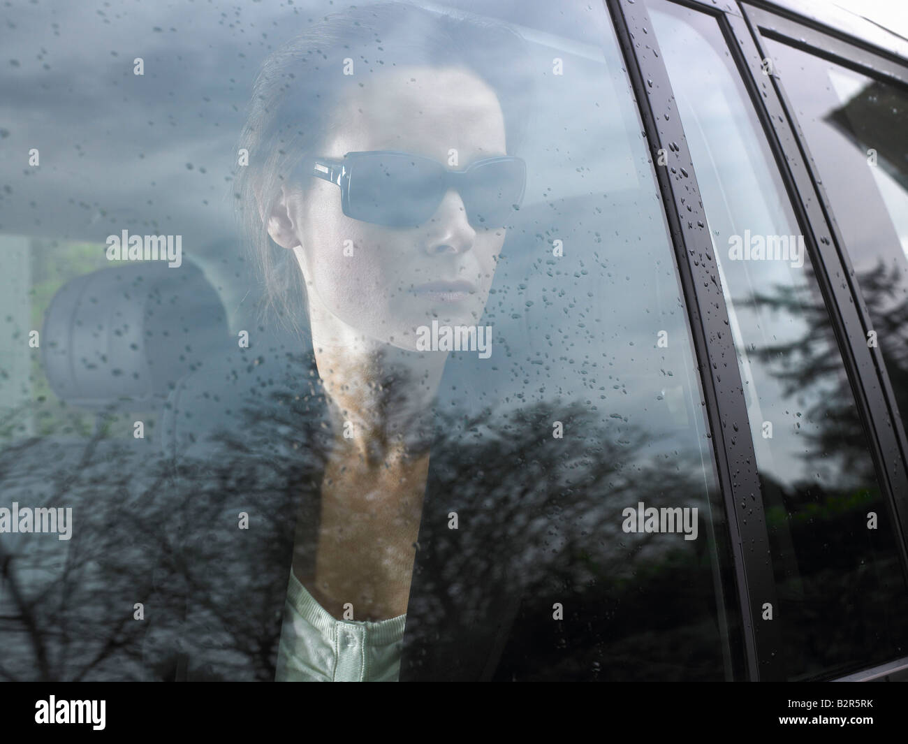 Woman looking through her car window Stock Photo - Alamy