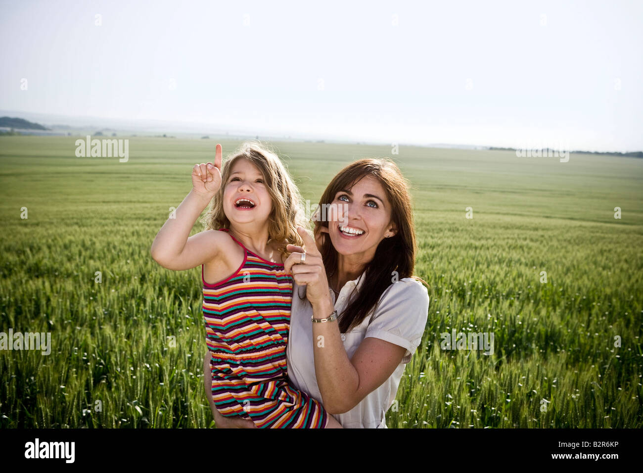 Woman and child pointing at sky Stock Photo - Alamy