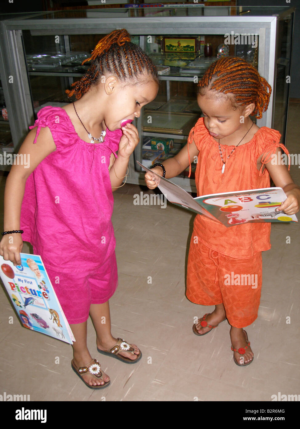 Two little girls looking at books Stock Photo - Alamy