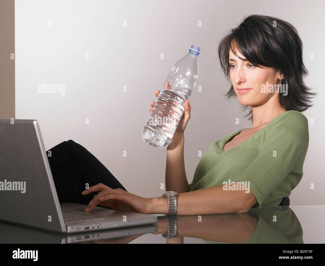 Woman working, drinking water Stock Photo - Alamy