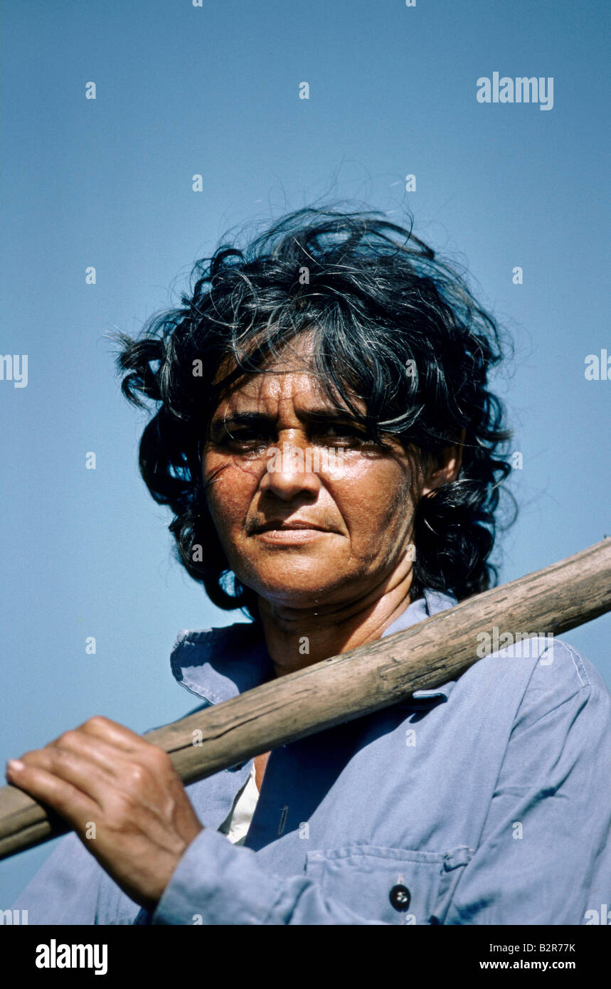 Female sugar cane farmer in a cooperative holding the wooden handle of ...