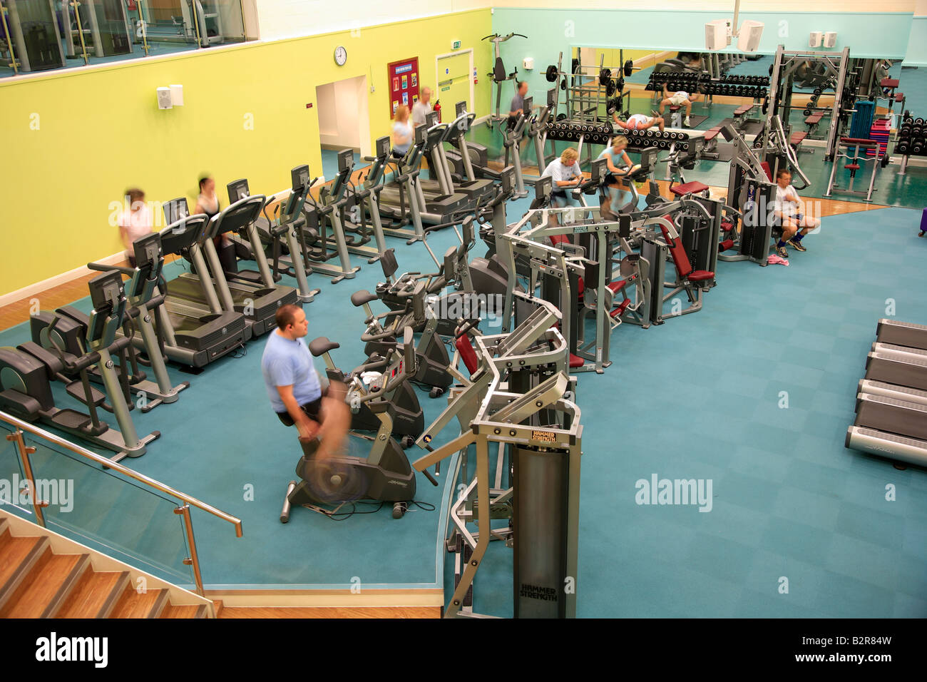 People at the gym on running machines, blurred for speed and power ...