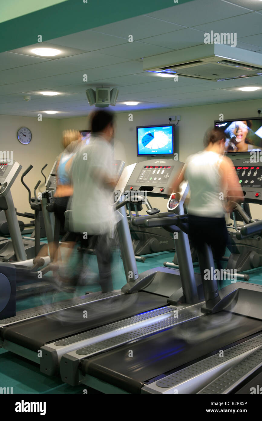People at the gym on running machines blurred for speed power effects ...