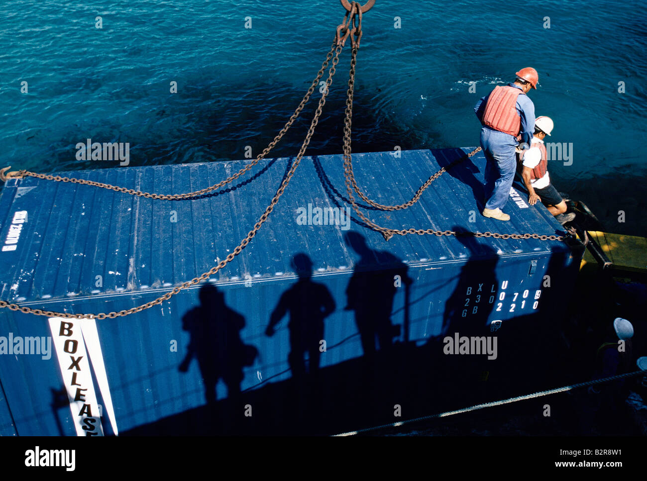 ascension island dock workers attaching crane chains to ship s ...