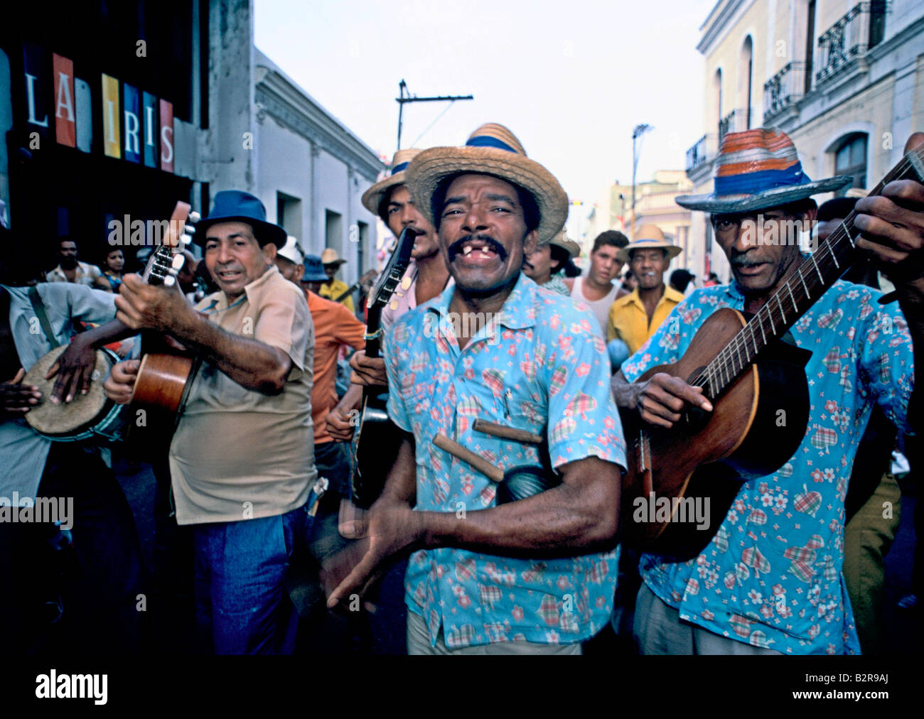 Musicians sing and play guitars in the street at the Santiago Carnival ...