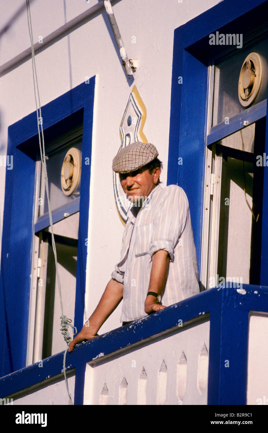 man standing on balcony of building squinting eyes due to strong ...