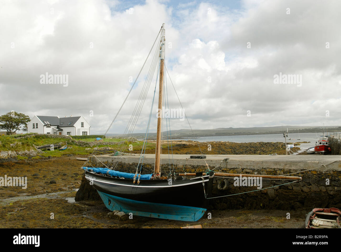Historic sailing boat at the pier in Carraroe, Connemara during low ...