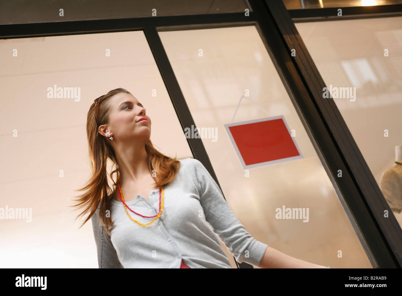 Young woman walking out of shop sale Stock Photo - Alamy
