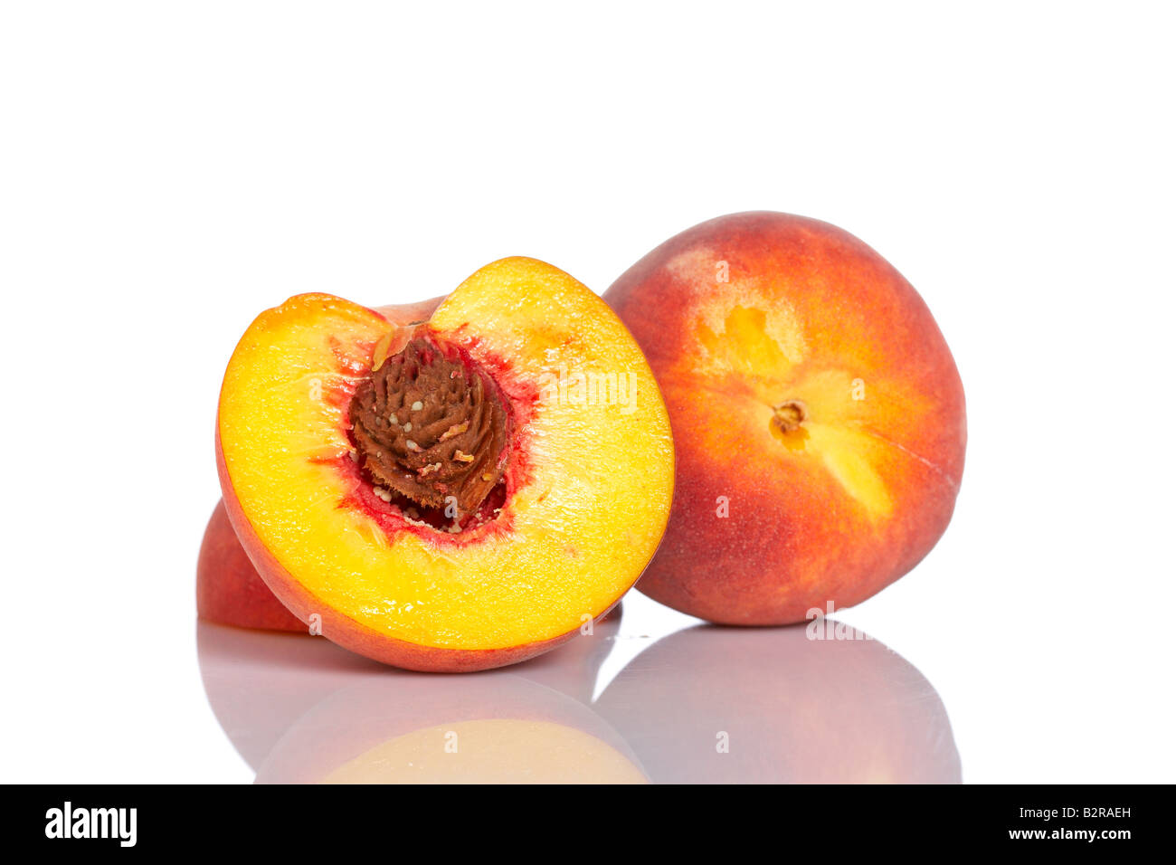Two half of peach fruit reflected on white background Shallow depth of ...