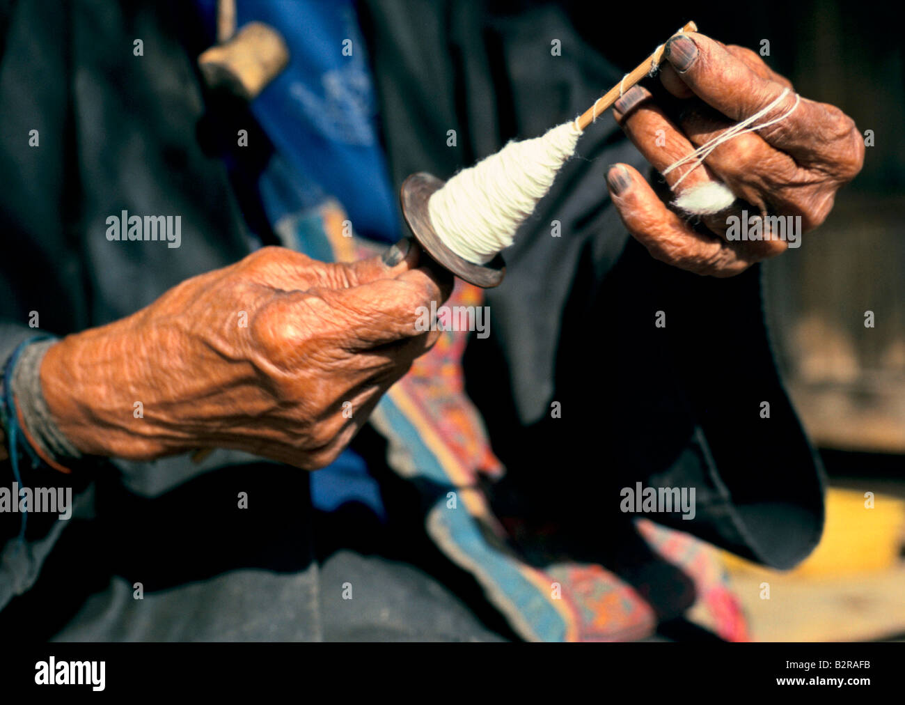 Hands of a Akha tribeswoman spinning cotton in a village near the ...