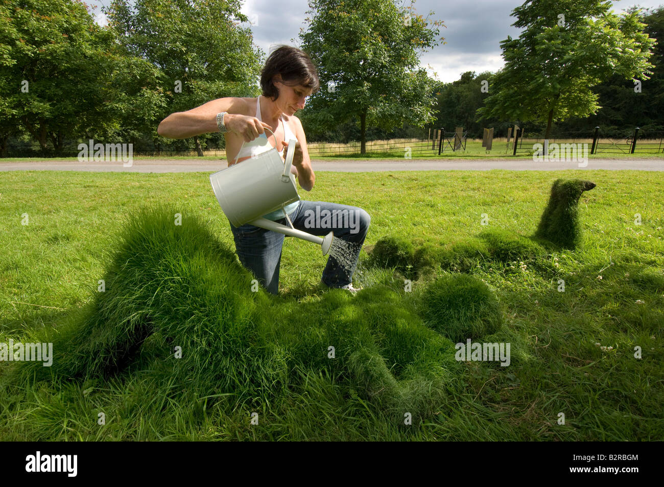 Artist Sharon Baker waters some of her grass sculptures of human ...