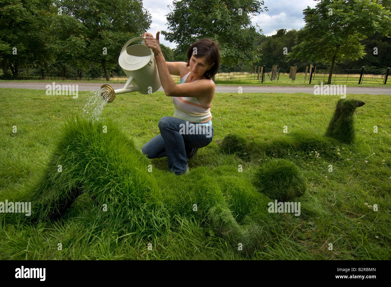 Artist Sharon Baker waters some of her grass sculptures of human ...