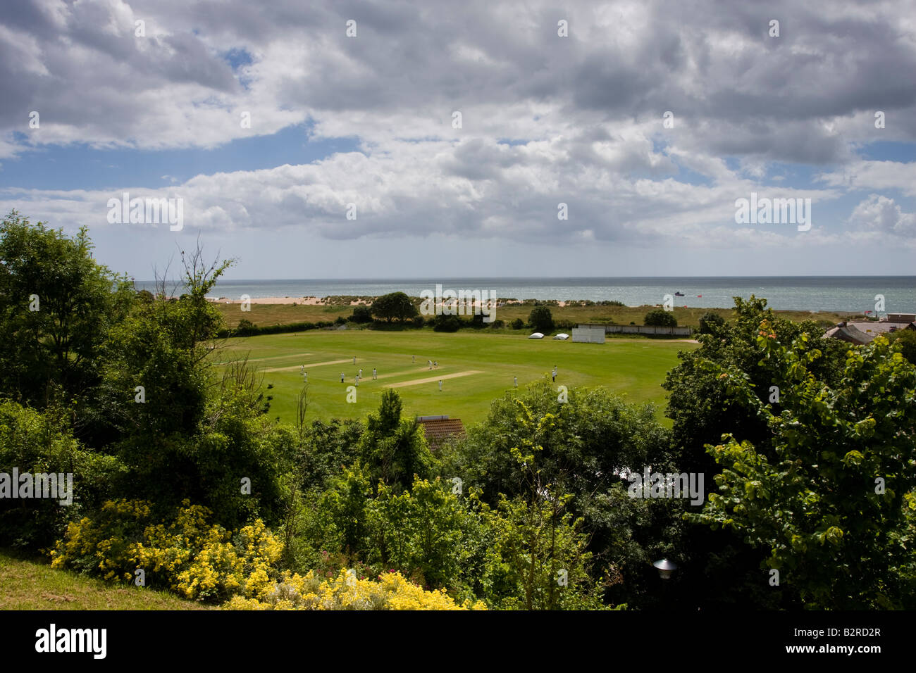 School Boys play Cricket near the sea front at Exmouth under cloudy Sky ...