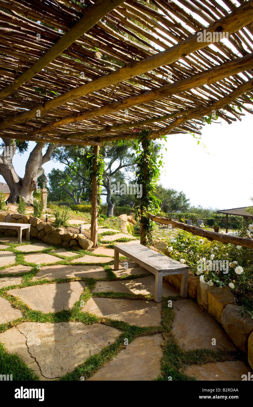Old wooden bench under a large canopy on stone patio Stock Photo - Alamy
