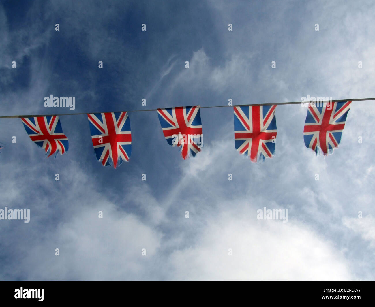 five small union jack british flags and blue sky Stock Photo - Alamy