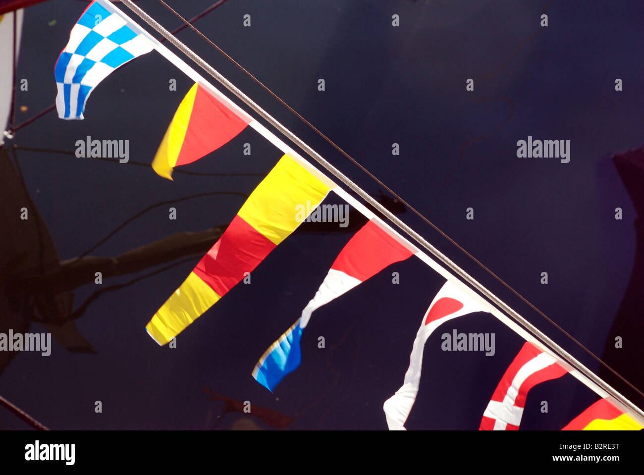 Colourful flag pennants with ships rigging reflected in water, Brest 08 ...