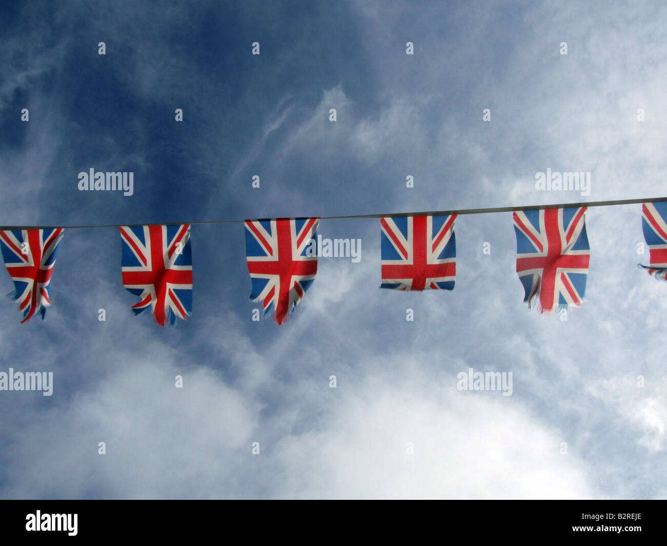 seven small union jack british flags and blue sky Stock Photo - Alamy