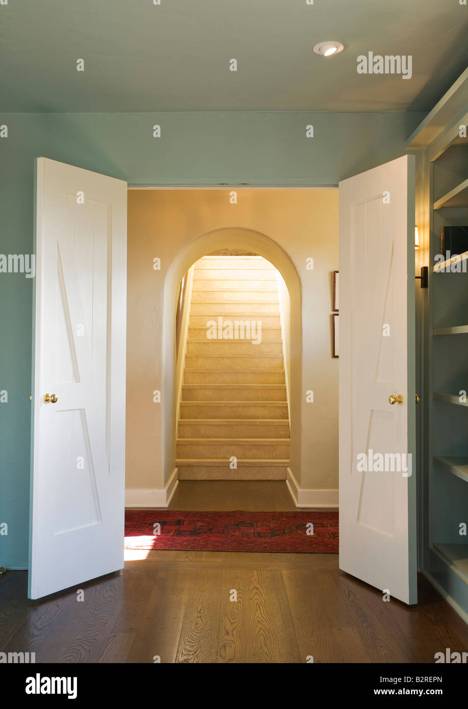 Open double doors leading to an upward staircase Stock Photo - Alamy