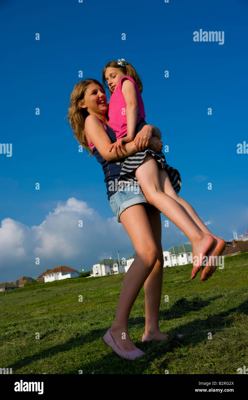 girl child lifting smaller child parkland Stock Photo - Alamy