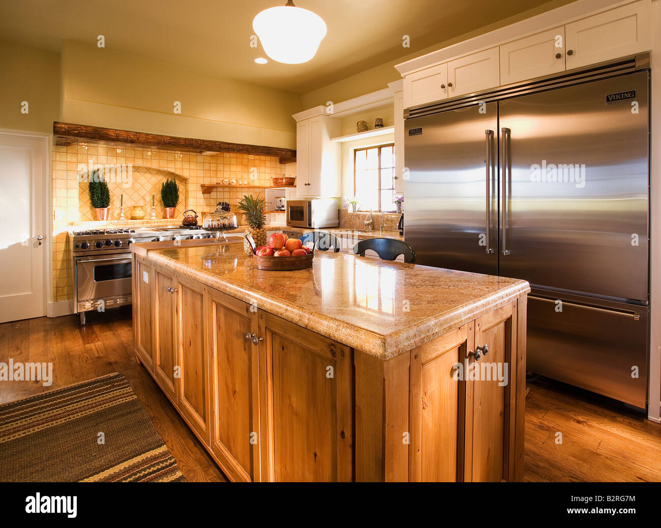 Interior of Kitchen with Island and large stainless steel refrigerator ...