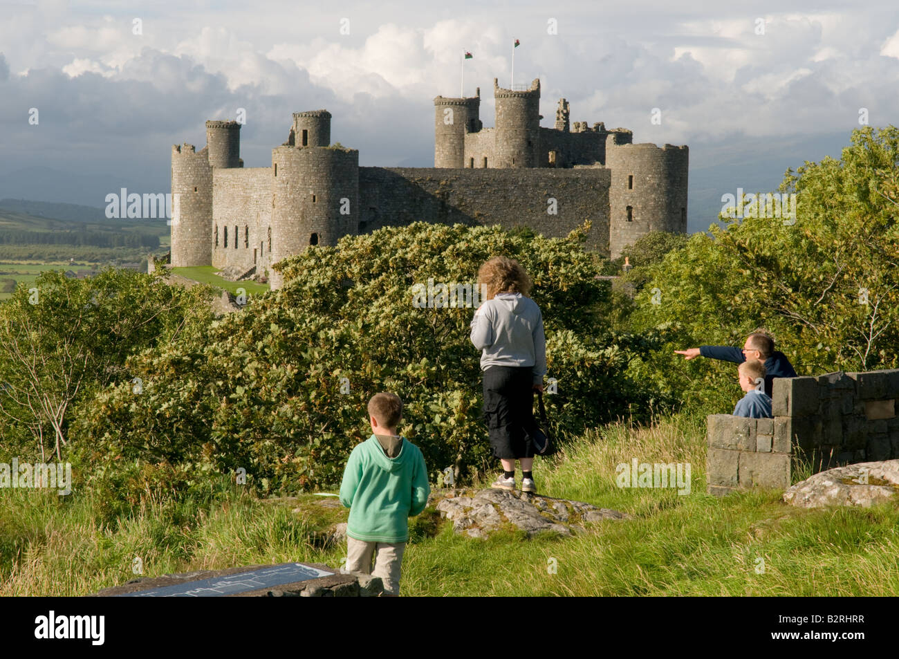 Family of tourists sightseers on holiday looking at Harlech Castle ...