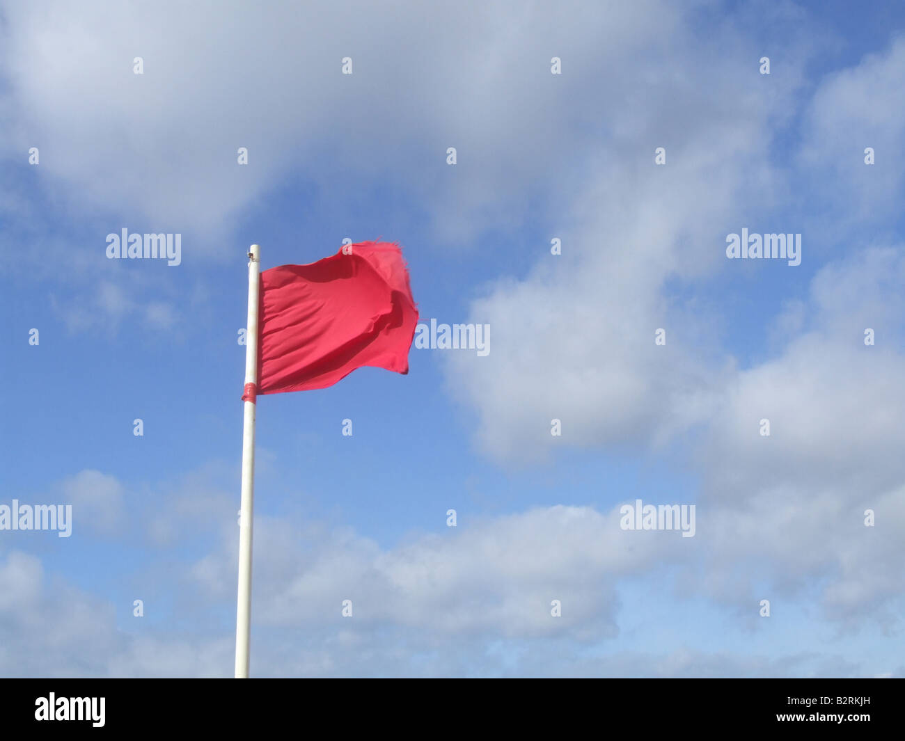 one red warning flag flying in wind by beach Stock Photo - Alamy