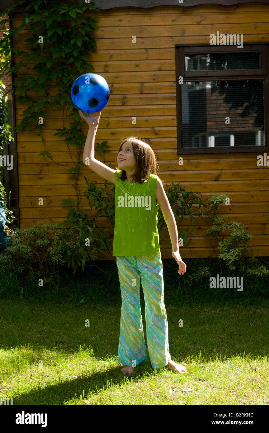 girl child holding blue ball in midair Stock Photo - Alamy
