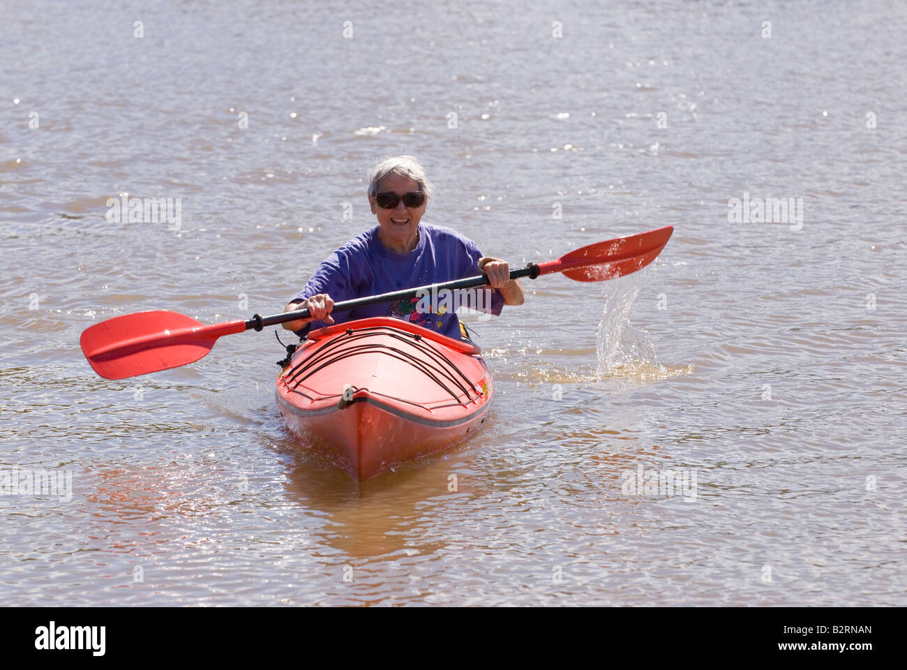 Mature woman paddling kayak Stock Photo - Alamy
