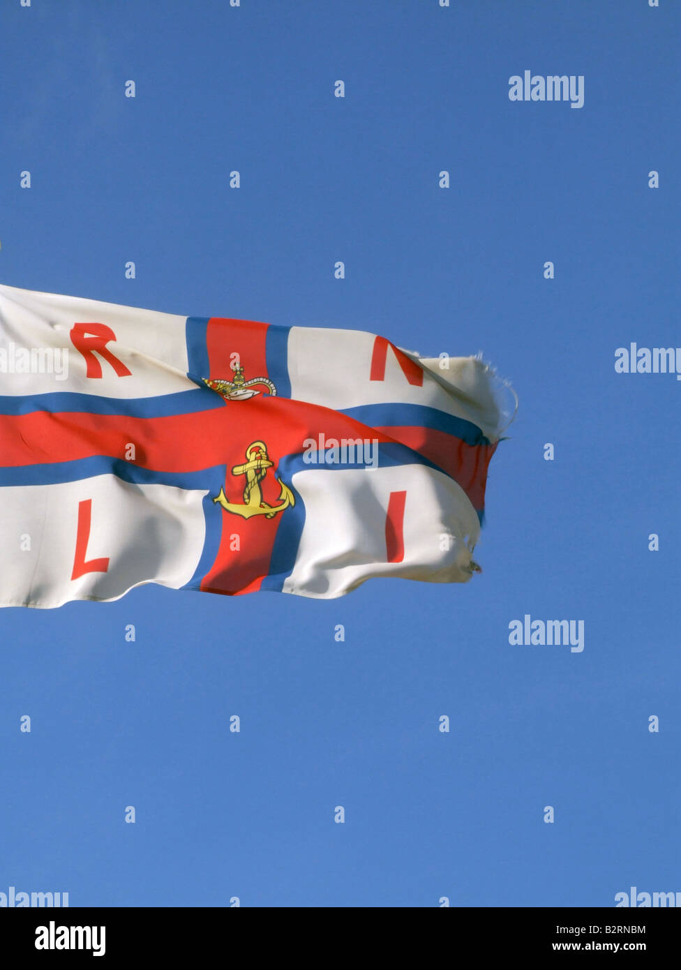 rnli lifeboat station flag flying in blue sky Stock Photo - Alamy